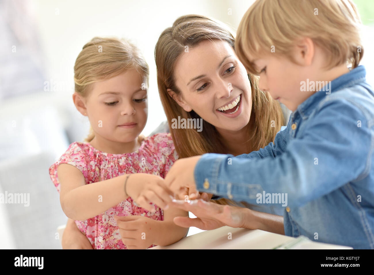 Kids and mother playing with stickers Stock Photo - Alamy