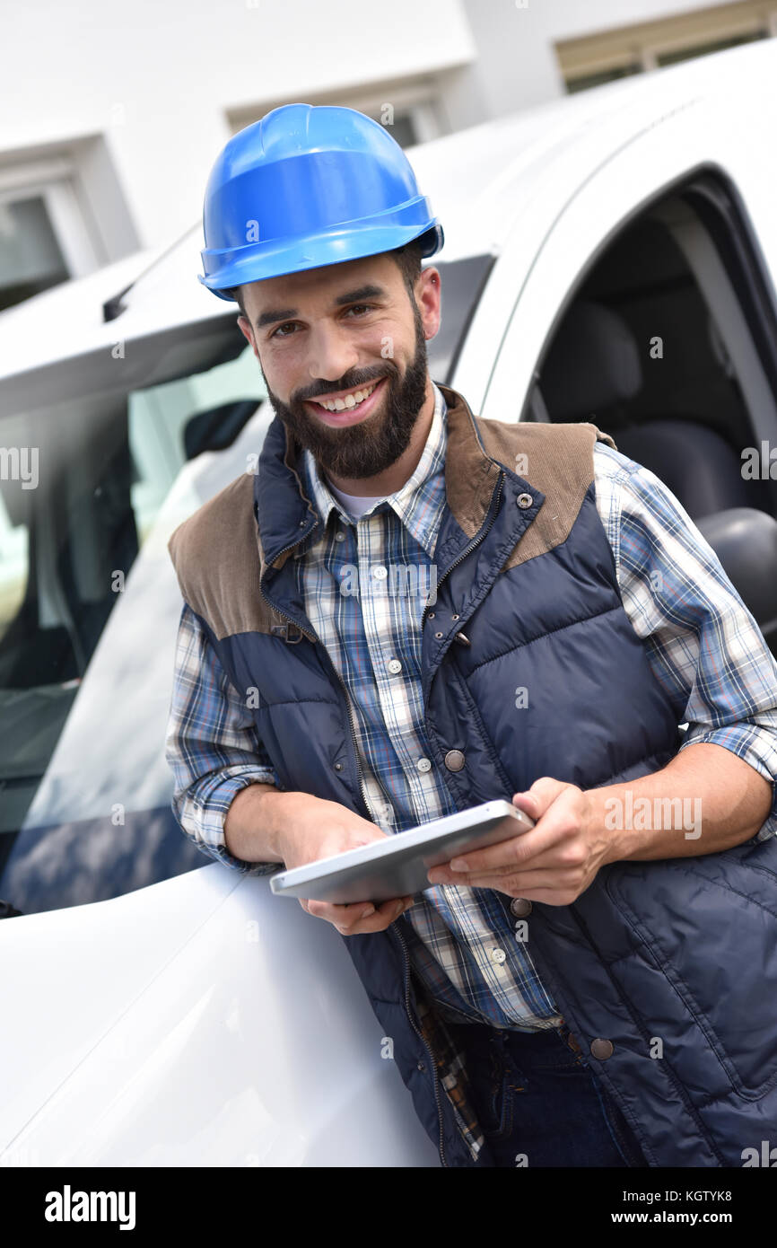 Technician standing by van and using tablet Stock Photo - Alamy