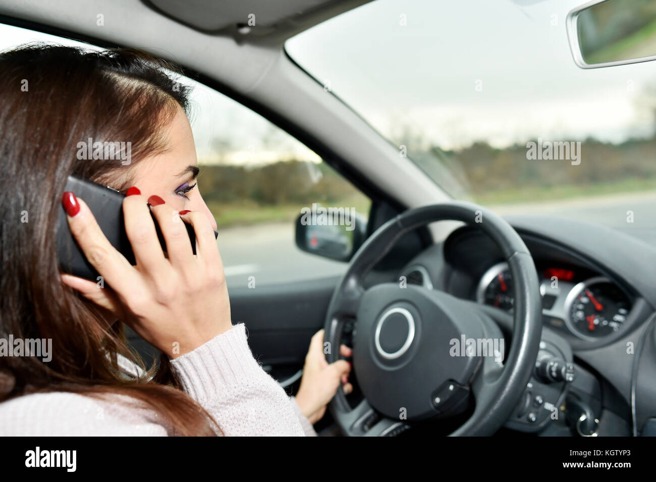 Woman talking on phone while driving Stock Photo - Alamy