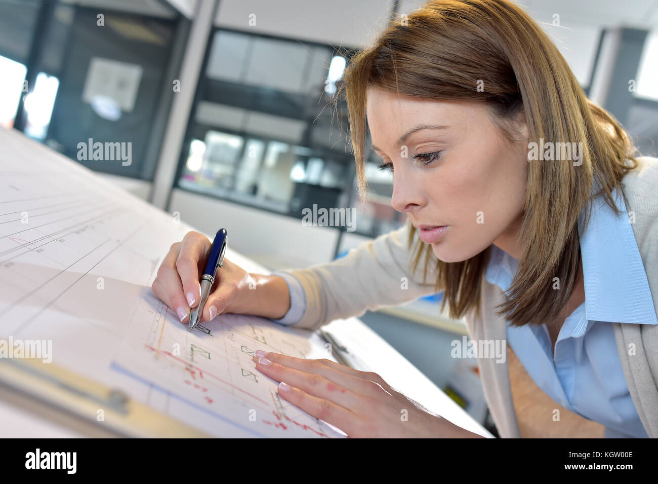 Woman engineer working on blueprint in office Stock Photo - Alamy