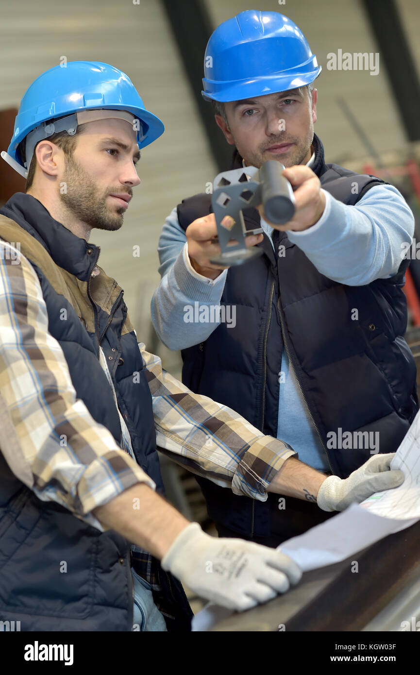 Engineer with mechanical worker checking on production Stock Photo - Alamy