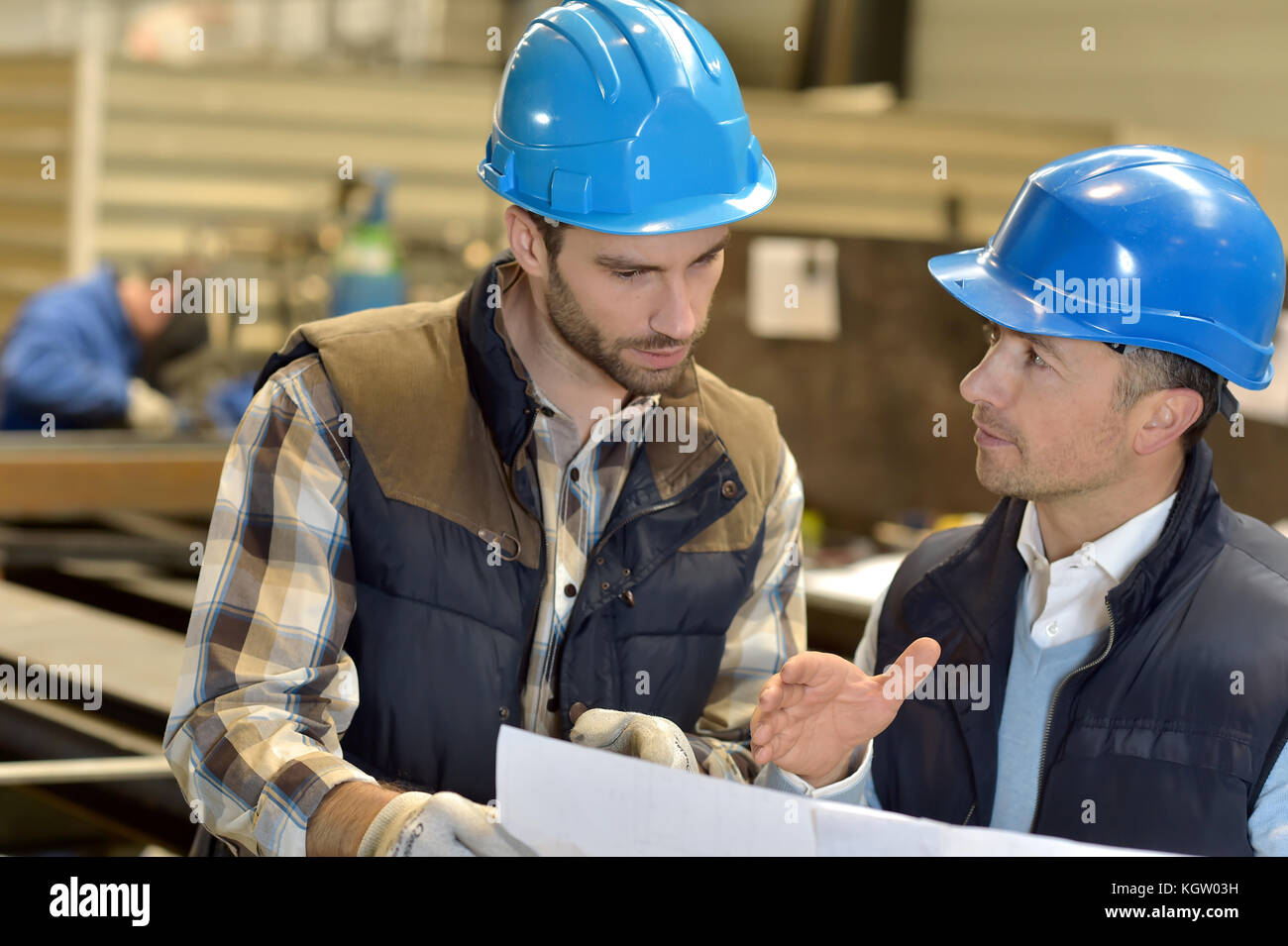 Engineer with mechanical worker checking on production Stock Photo - Alamy
