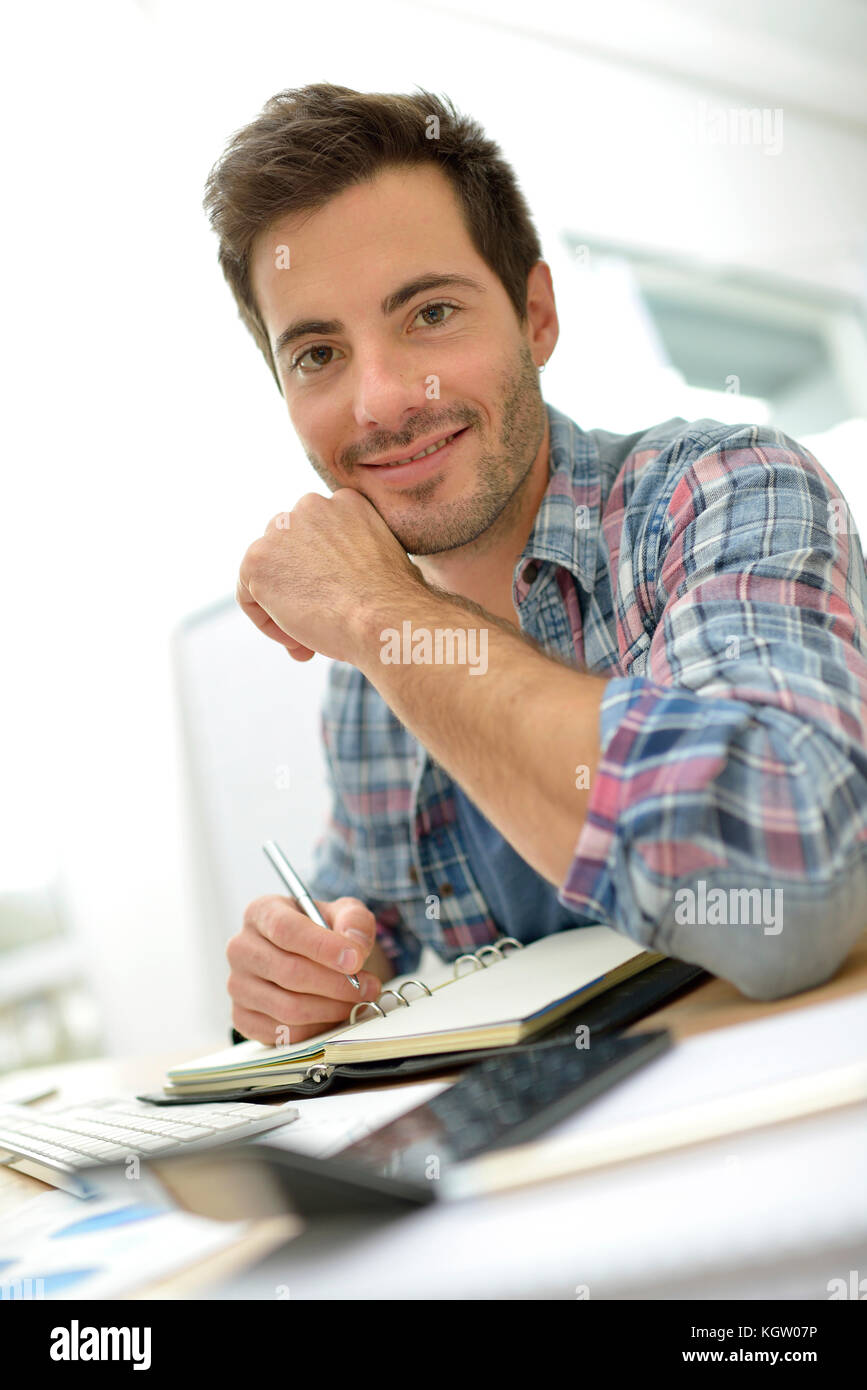 Smiling office worker sitting at desk Stock Photo - Alamy