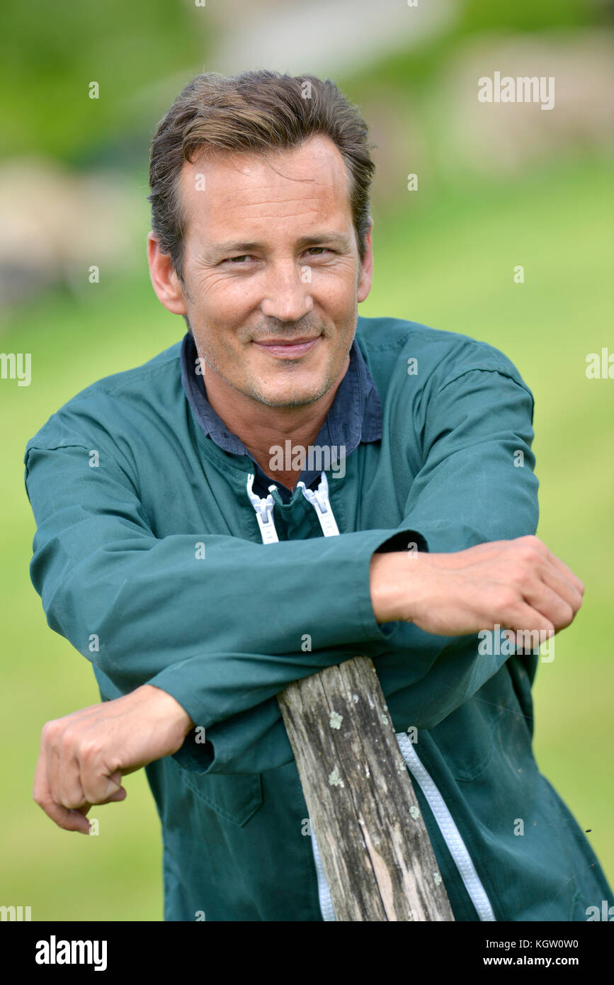 Smiling farmer standing in country field Stock Photo - Alamy