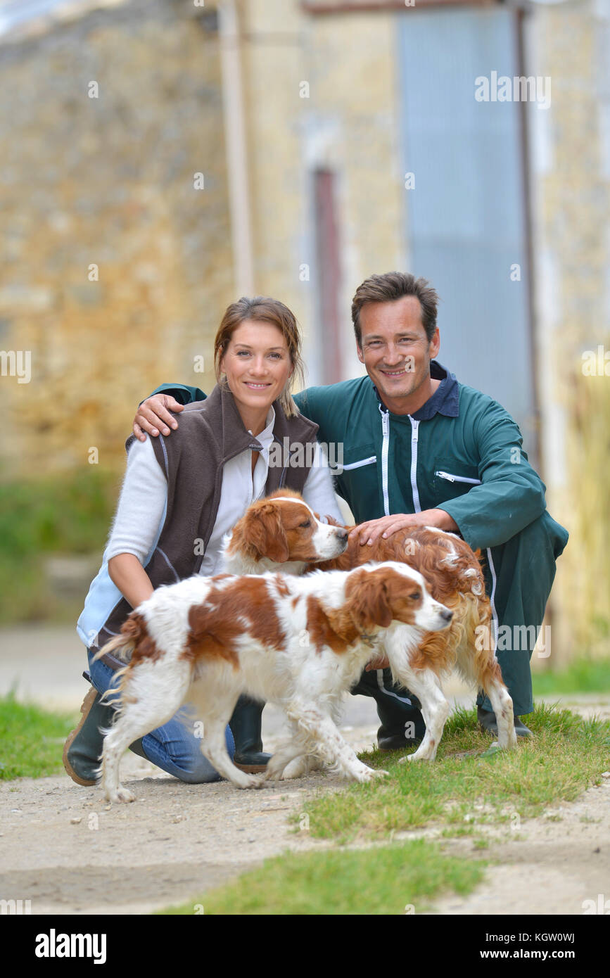 Couple of farmers with dogs around farm house Stock Photo - Alamy