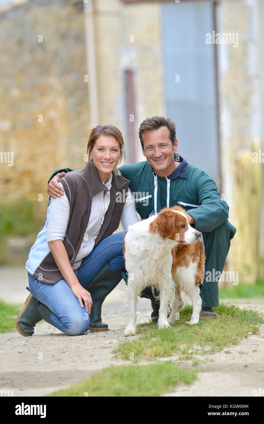 Couple of farmers with dogs around farm house Stock Photo - Alamy