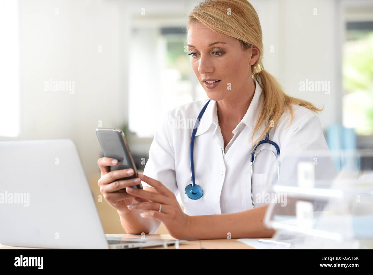 Portrait of nurse in office using smartphone Stock Photo - Alamy