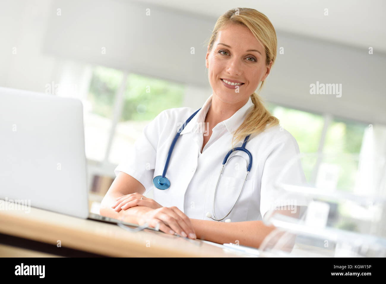 Portrait of doctor in office working on laptop Stock Photo - Alamy
