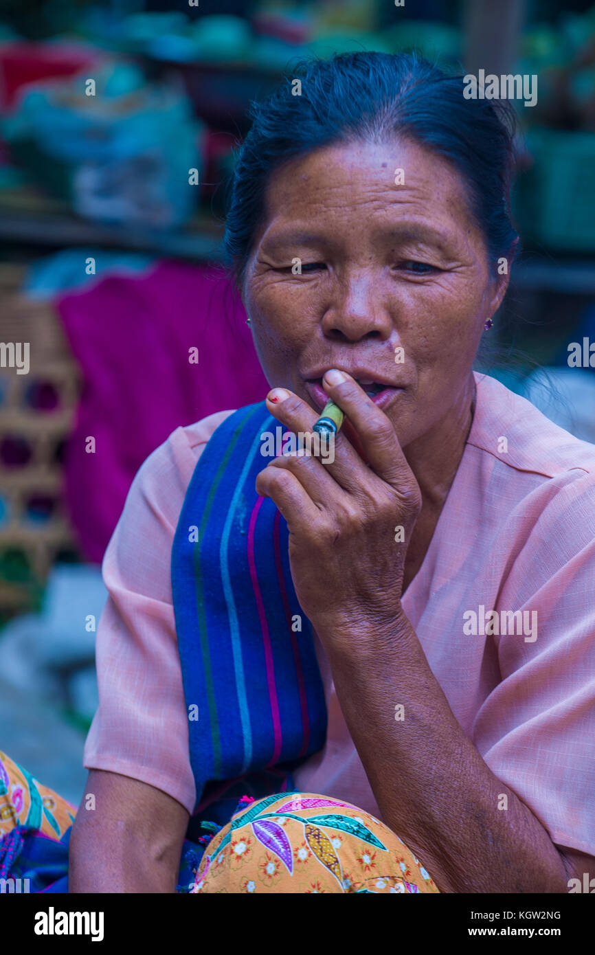 Woman smoking a cheroot cigar in market in bagan, Myanmar Stock Photo ...