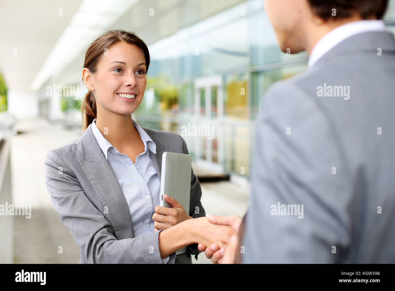 Businesswoman shaking hand to partner Stock Photo - Alamy