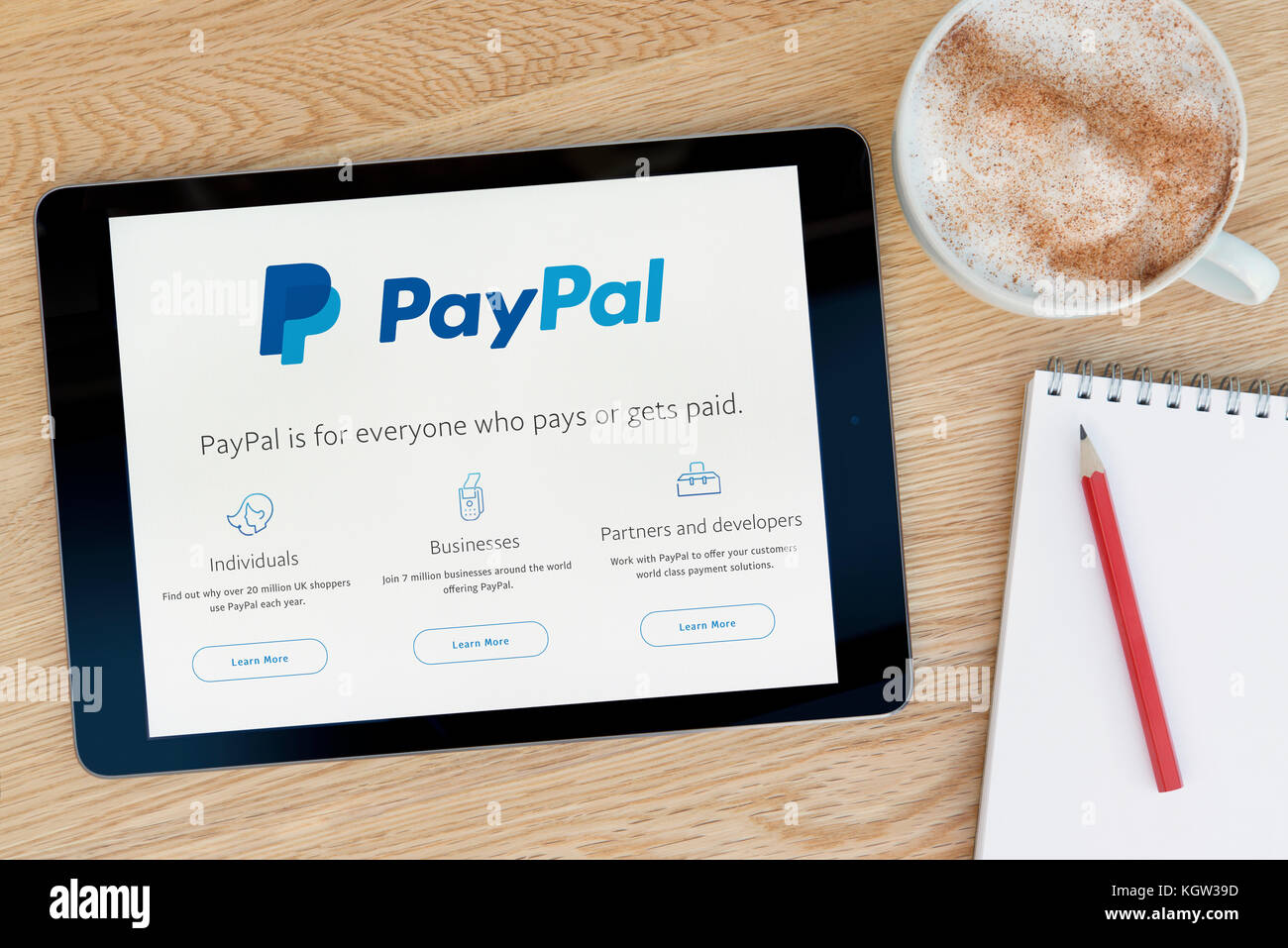 The PayPal website features on an iPad tablet device which rests on a ...