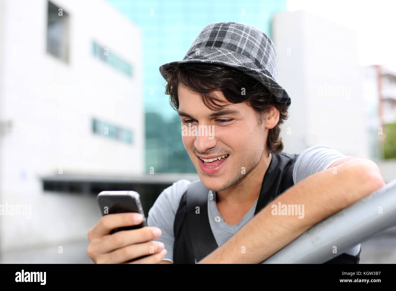 Portrait of young guy sending message with smartphone Stock Photo - Alamy