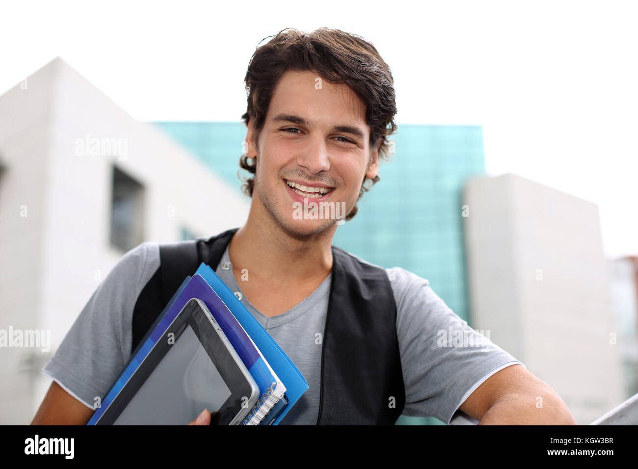 Cheerful student standing outside college building Stock Photo - Alamy