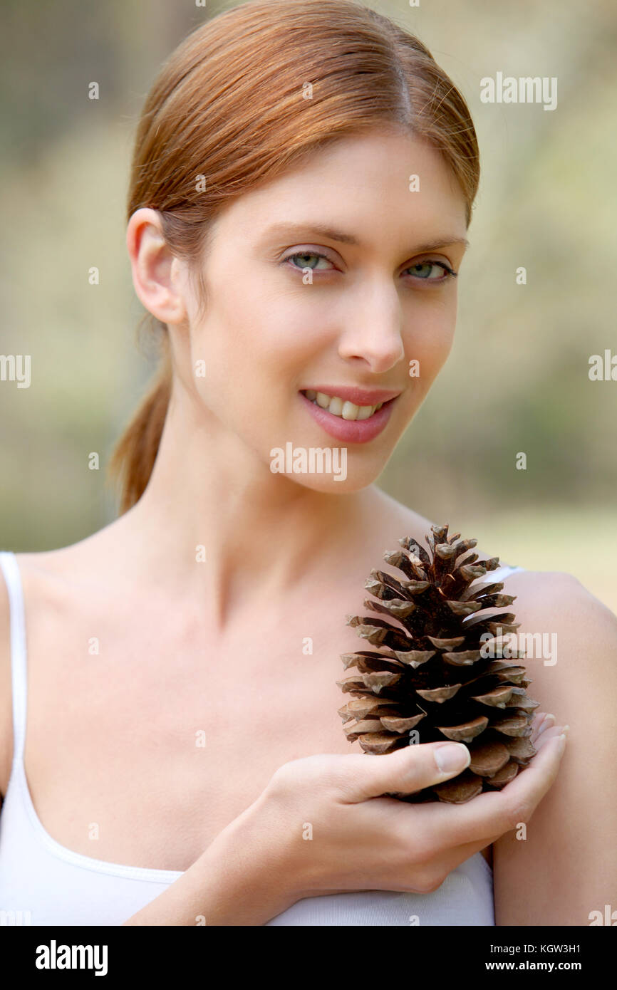 Portrait of beautiful woman holding pine cone Stock Photo - Alamy