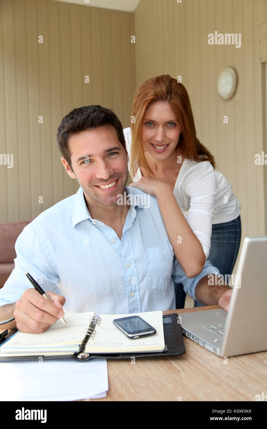 Self-employed man working at home with wife Stock Photo - Alamy