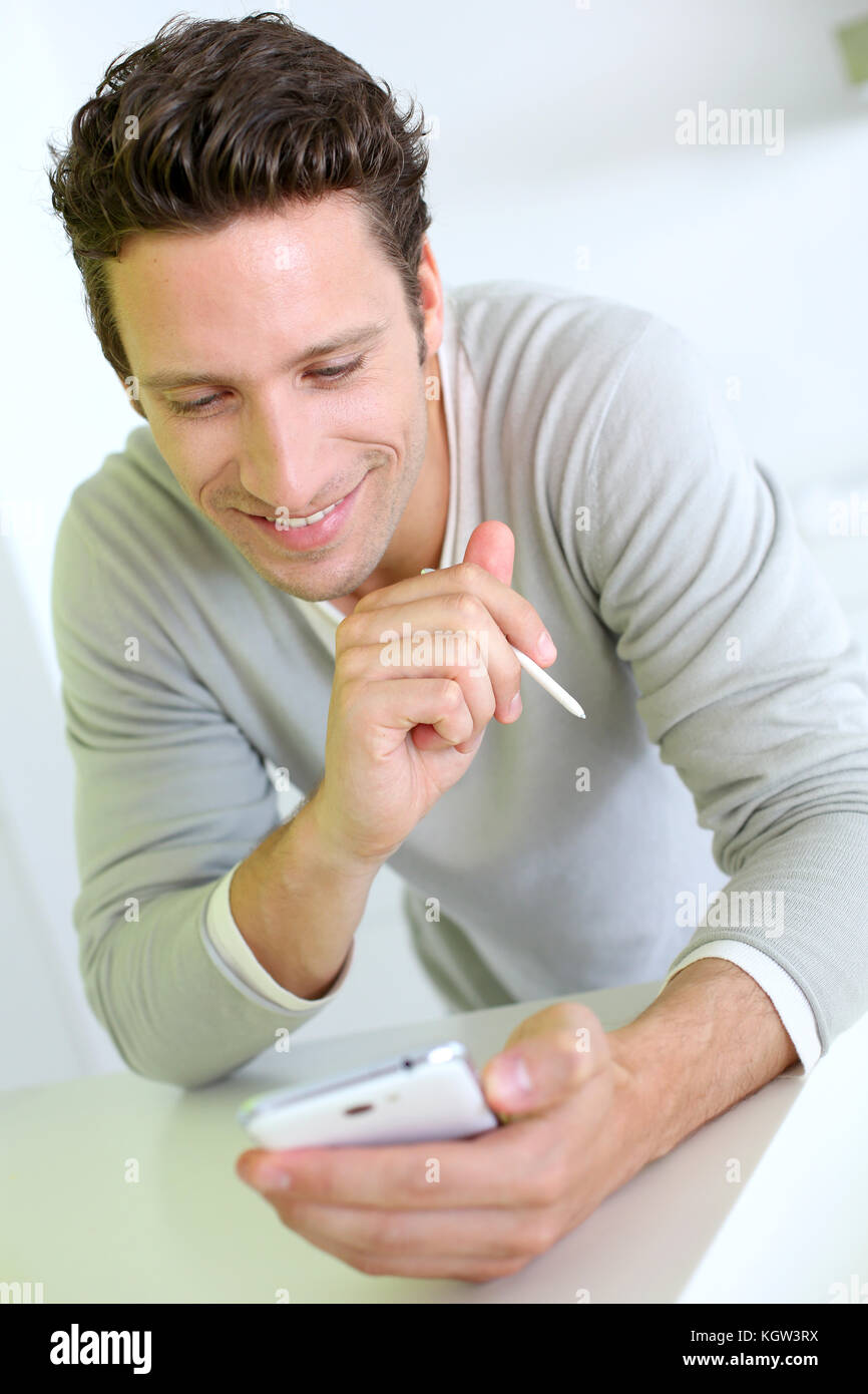 Cheerful guy using smartphone Stock Photo - Alamy