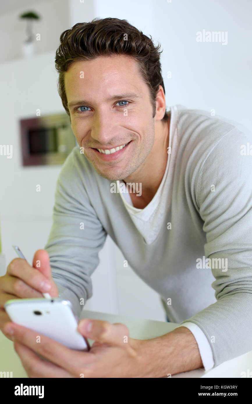 Cheerful guy using smartphone Stock Photo - Alamy