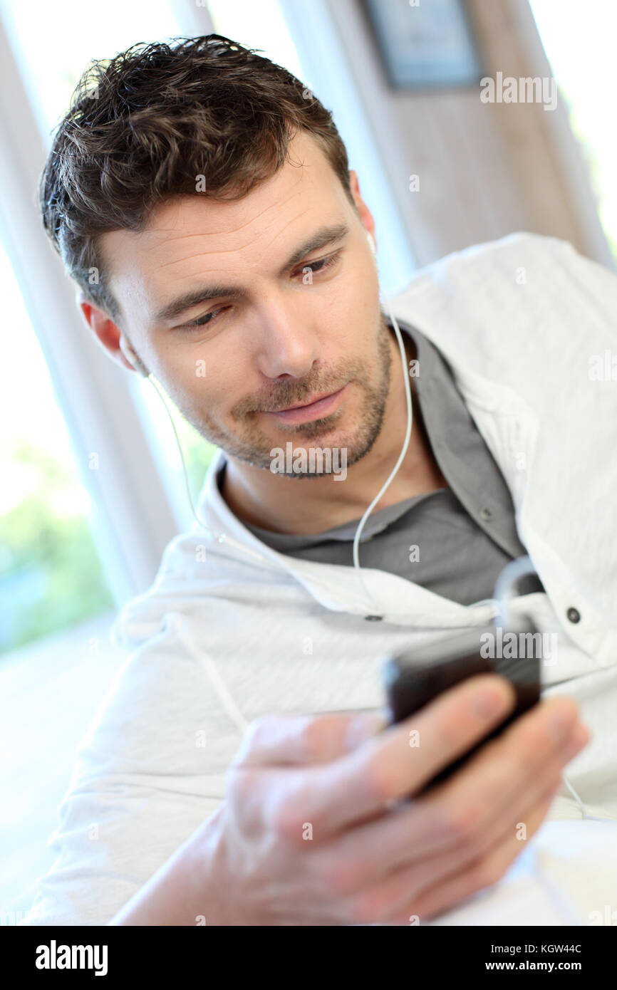 Young man using mobile phone with handsfree headset Stock Photo - Alamy