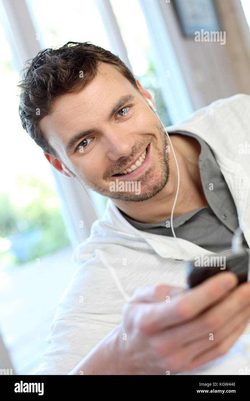 Young man using mobile phone with handsfree headset Stock Photo - Alamy