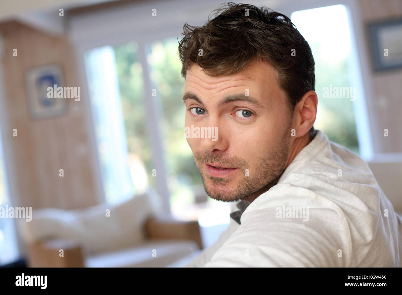 Portrait of young smiling man relaxing in sofa Stock Photo - Alamy