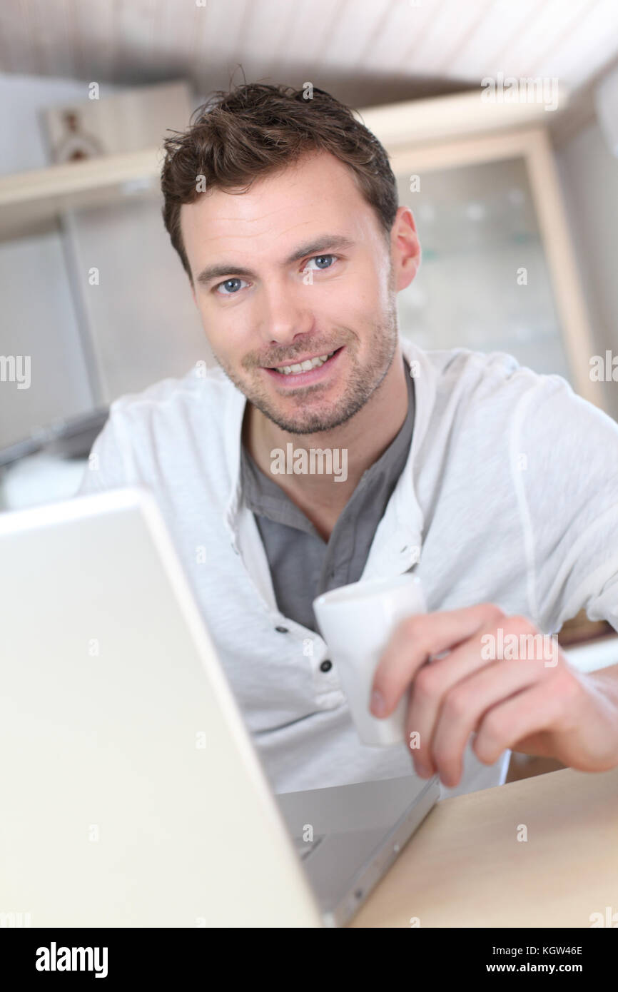Man drinking coffee in front of laptop computer Stock Photo - Alamy
