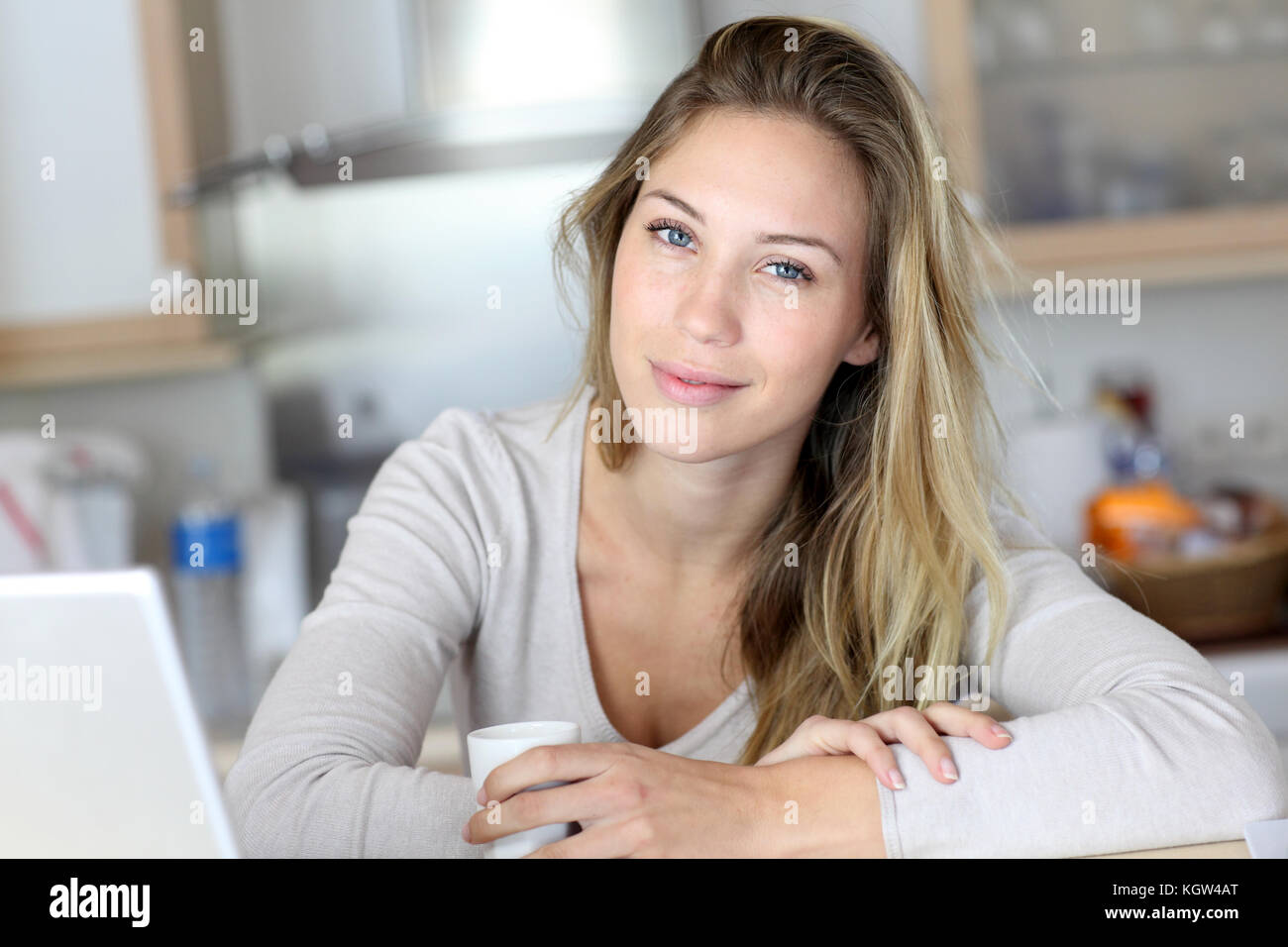 Woman checking email on laptop computer while drinking coffee Stock ...