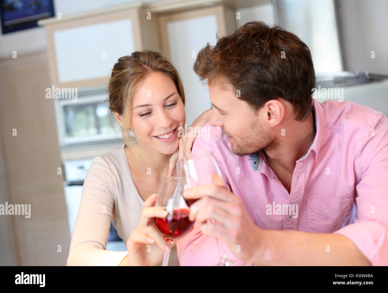 Happy couple cheering with glass of wine Stock Photo - Alamy