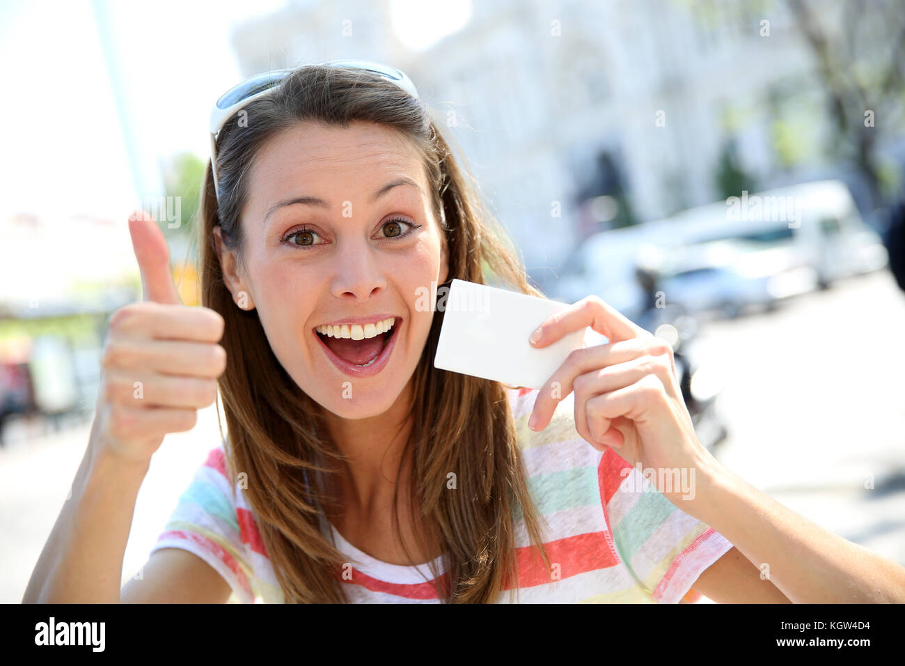 Cheerful girl in showing tourist pass Stock Photo - Alamy