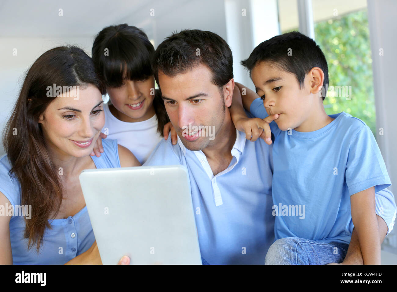 Parents and children using electronic tablet at home Stock Photo - Alamy