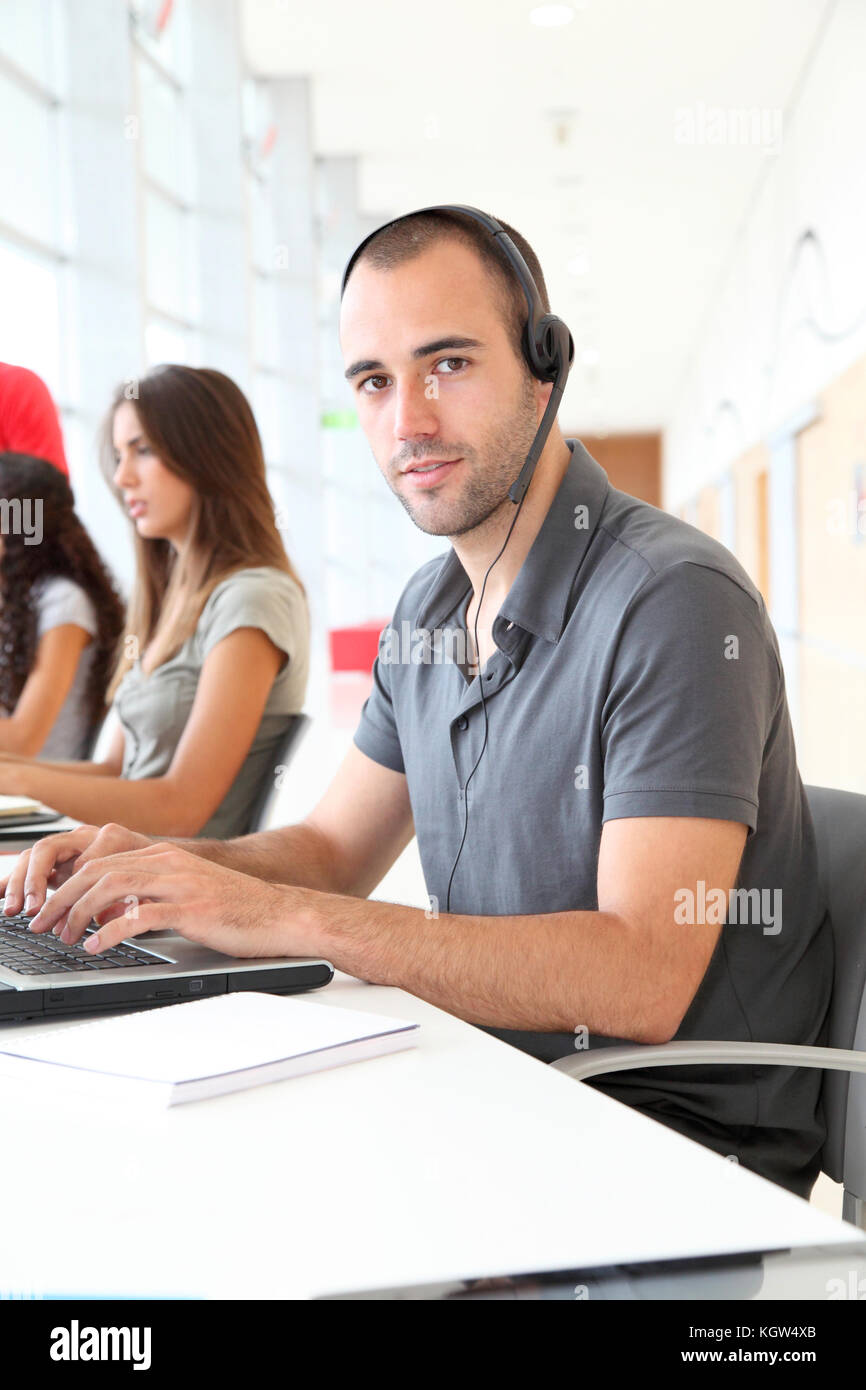 Customer service employee with headphones on Stock Photo - Alamy