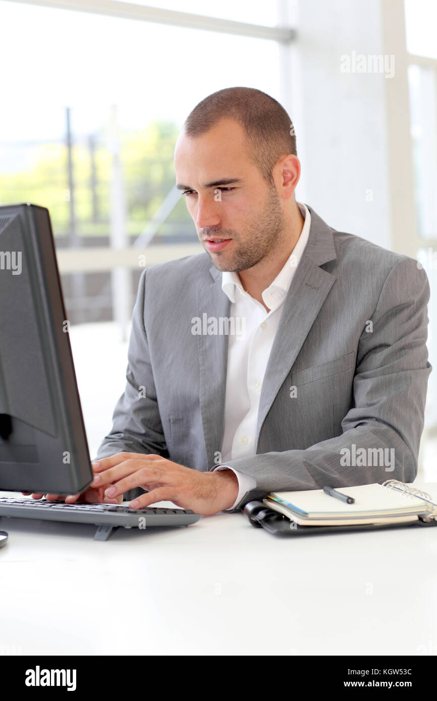 Salesman working on desktop computer Stock Photo - Alamy