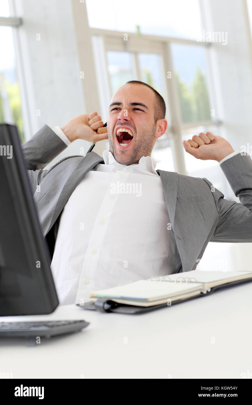 Portrait of relaxed salesman yawning in office Stock Photo - Alamy