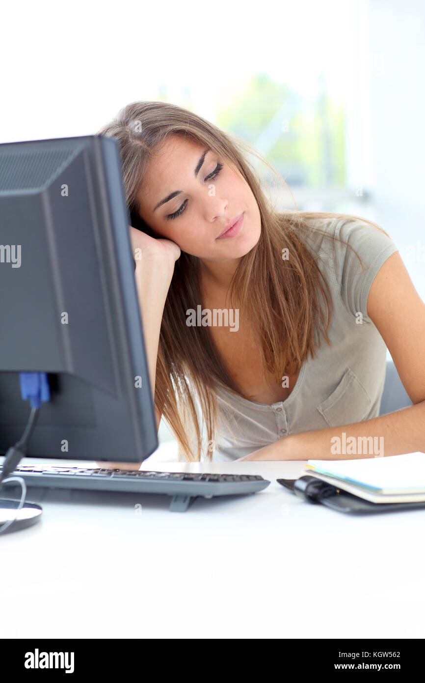 Exhausted young woman sitting in front of computer Stock Photo - Alamy