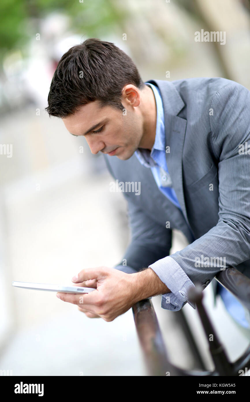 Man using electronic tablet outside in town Stock Photo - Alamy