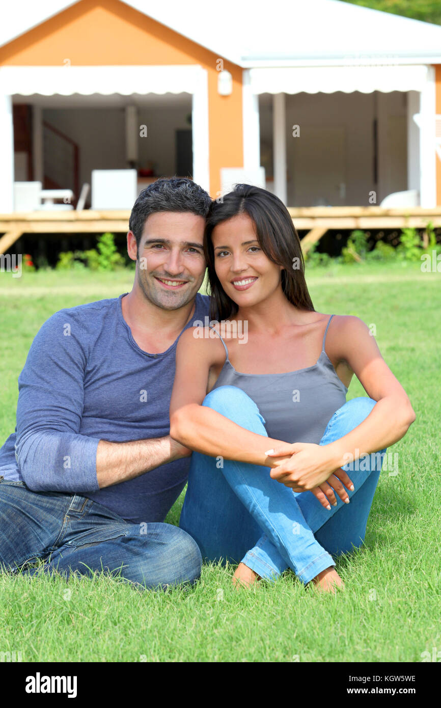 Young couple sitting in front of brand new home Stock Photo - Alamy