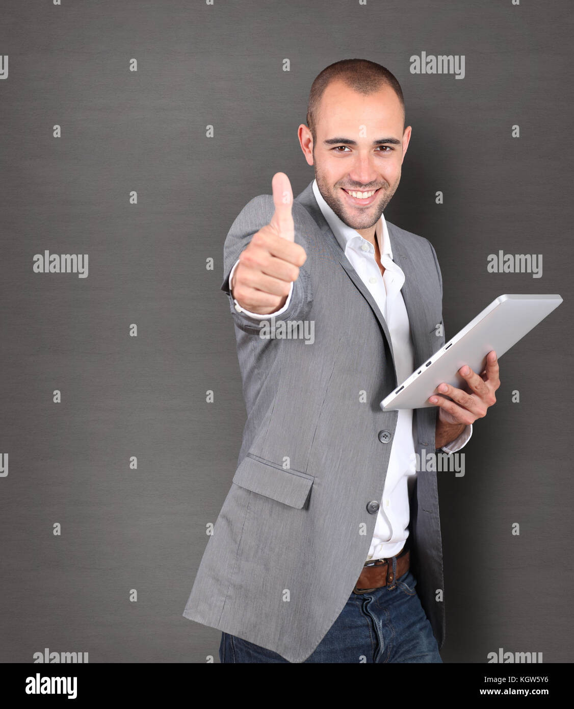 Cool businessman using touchpad on grey background Stock Photo - Alamy