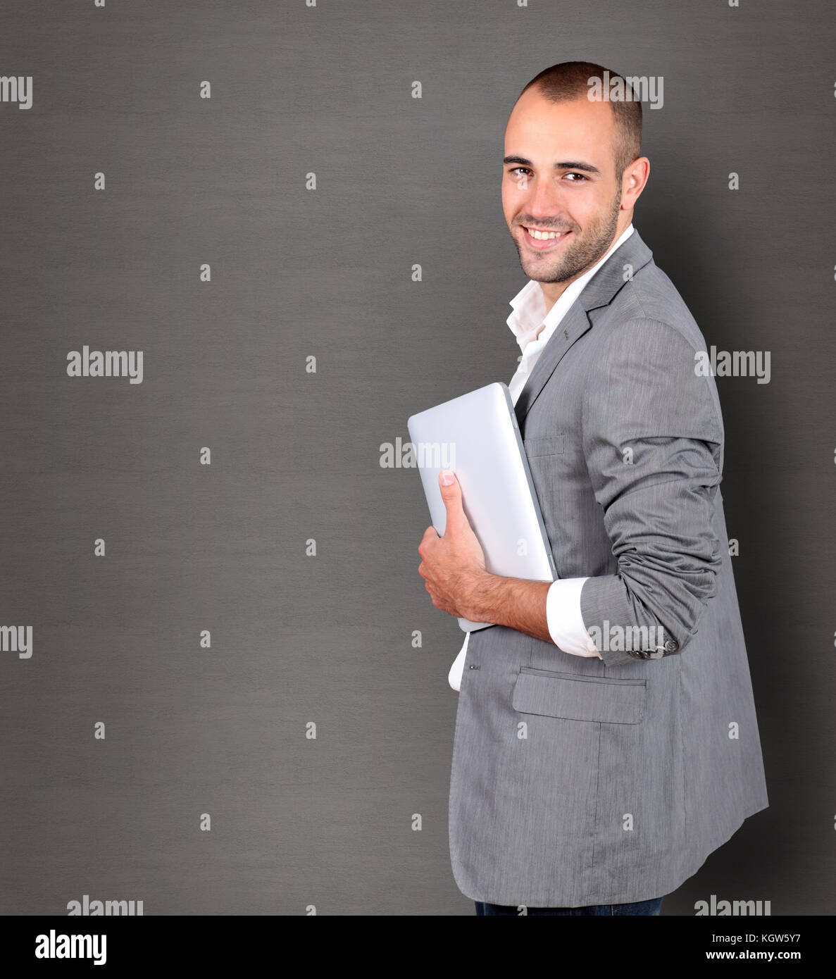 Cool businessman using touchpad on grey background Stock Photo - Alamy