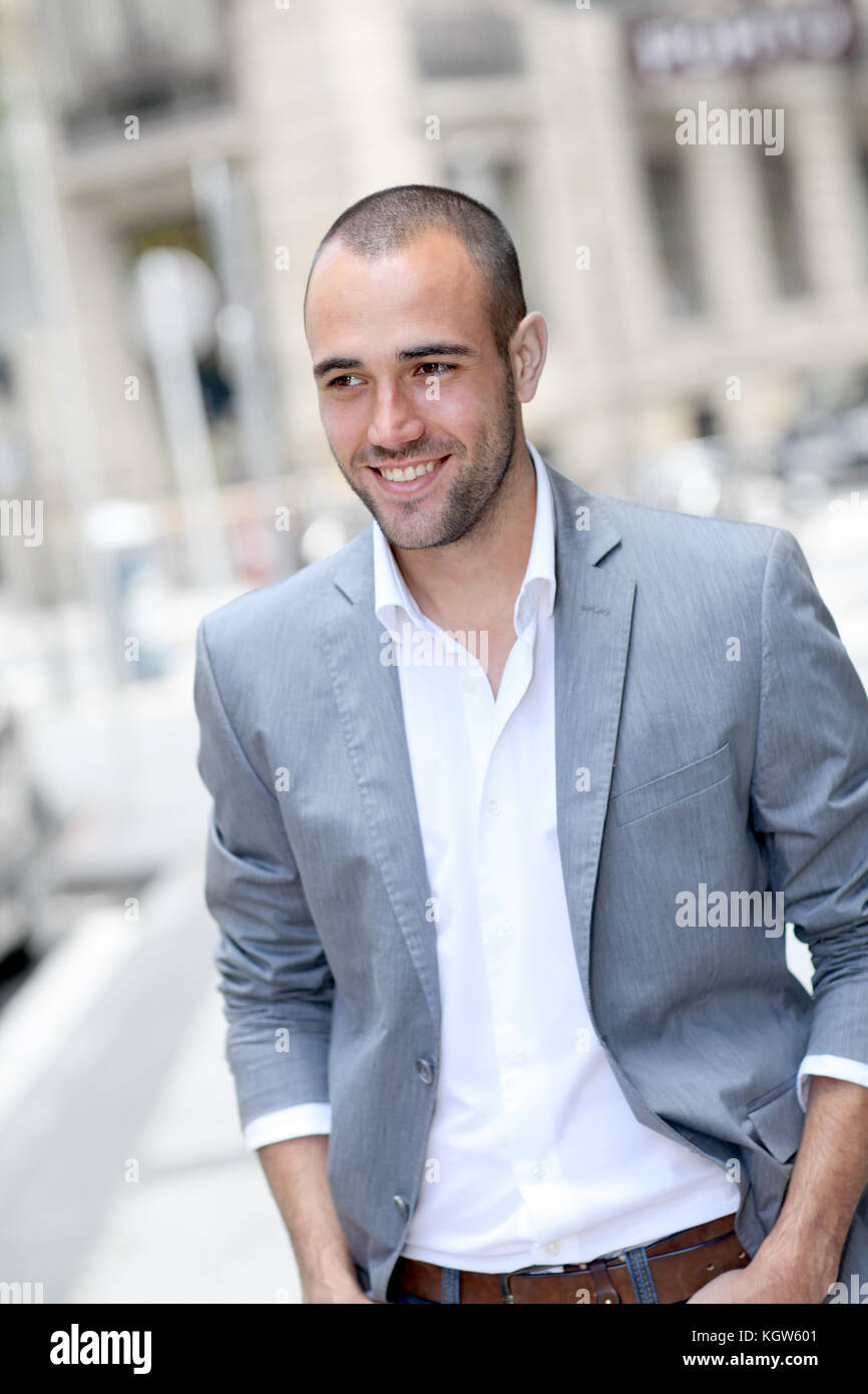 Cheerful young man walking in town Stock Photo - Alamy