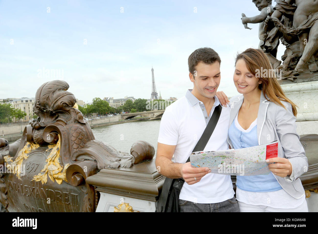 Couple reading tourist map on the Bridge Alexander the Third Stock ...