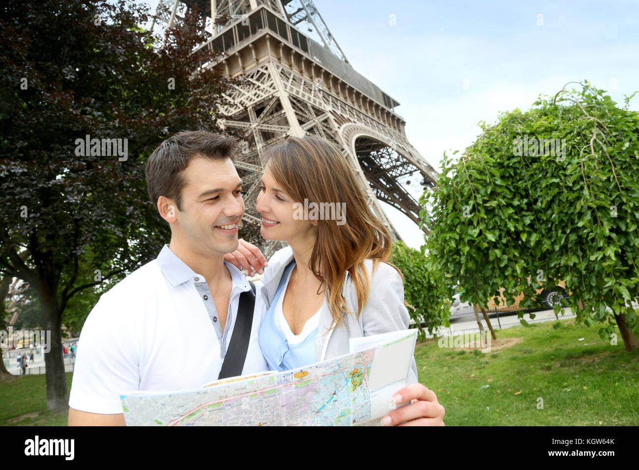 Couple reading tourist map in front of the Eiffel tower Stock Photo - Alamy