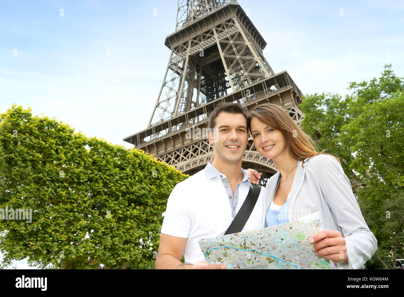 Couple reading tourist map in front of the Eiffel tower Stock Photo - Alamy