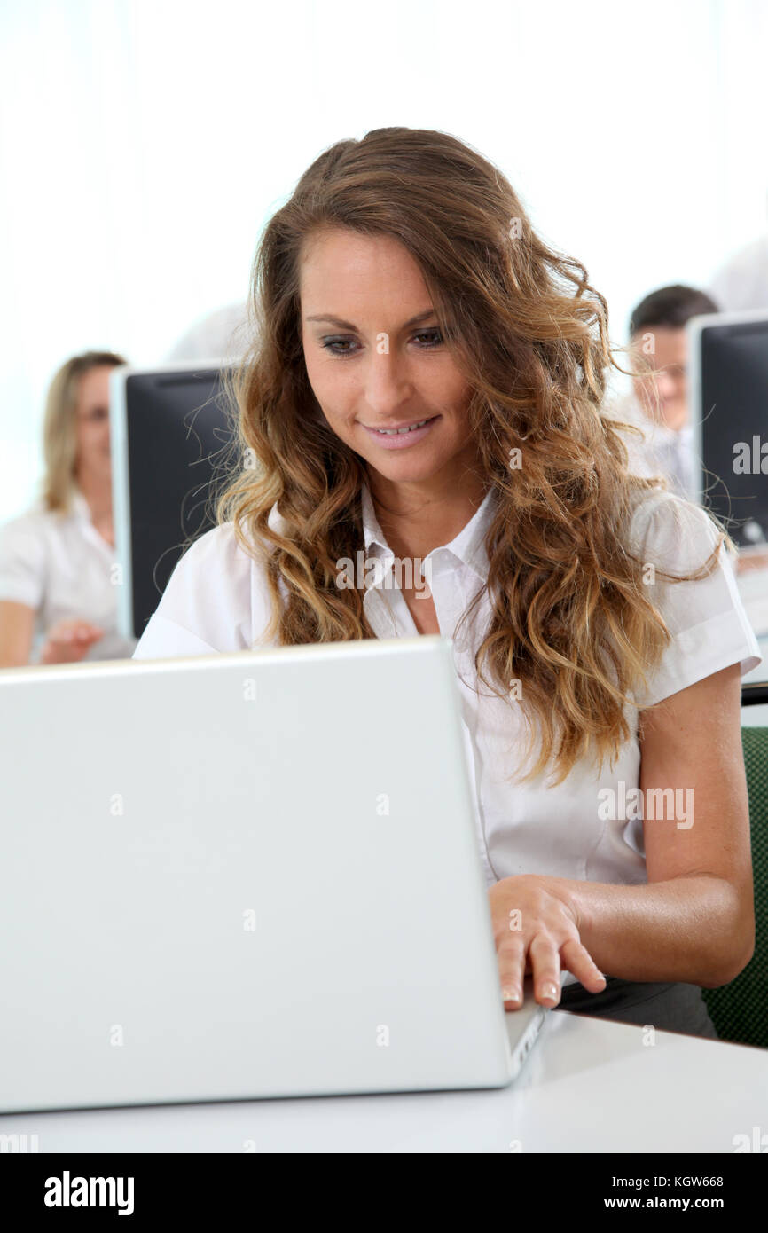 Smiling office worker in front of laptop computer Stock Photo - Alamy