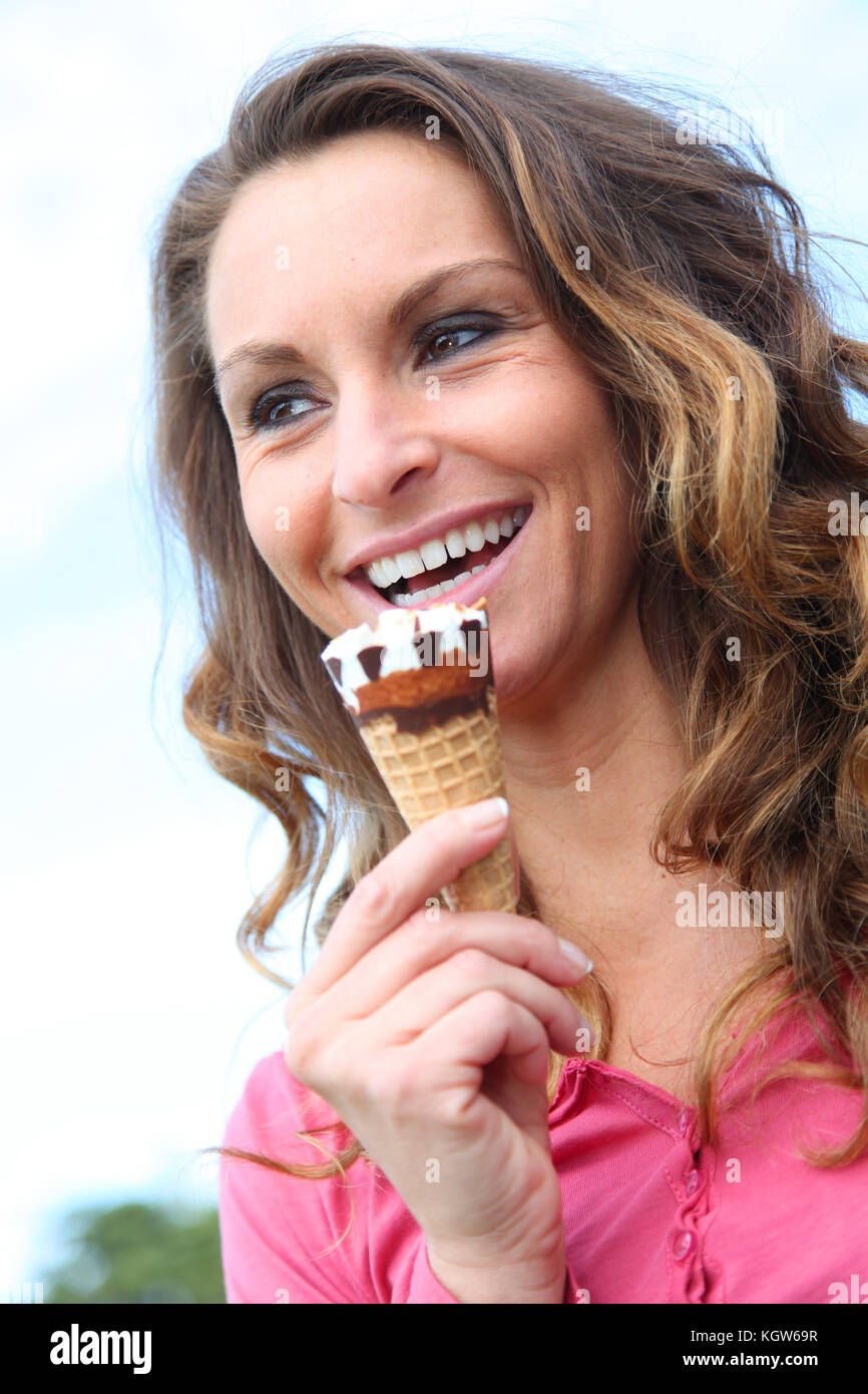 Portrait of woman eating ice cream cone Stock Photo - Alamy