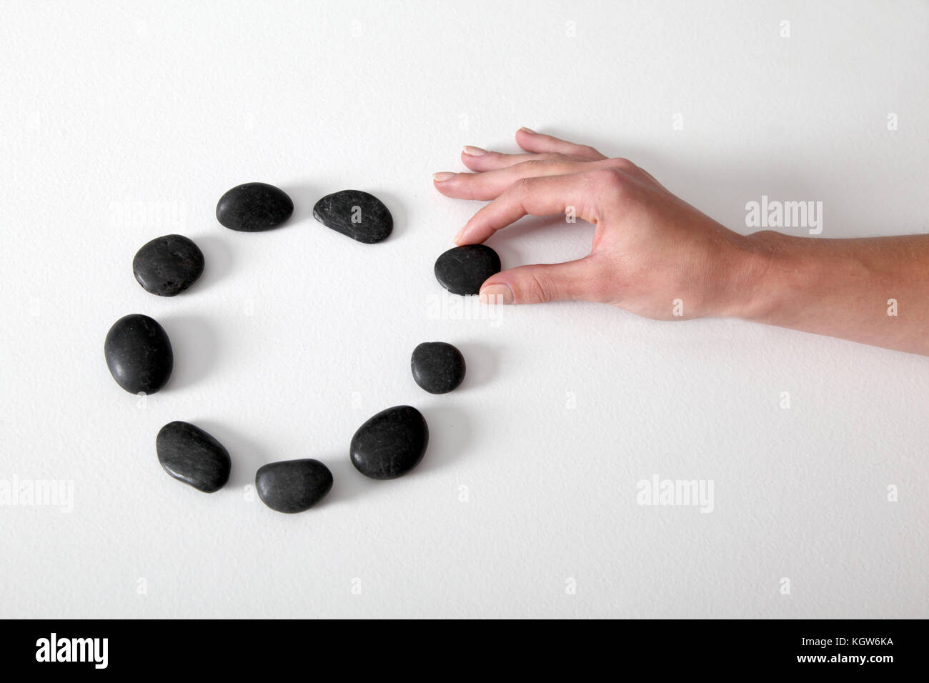 Human hand arranging line of pebbles in circle Stock Photo - Alamy