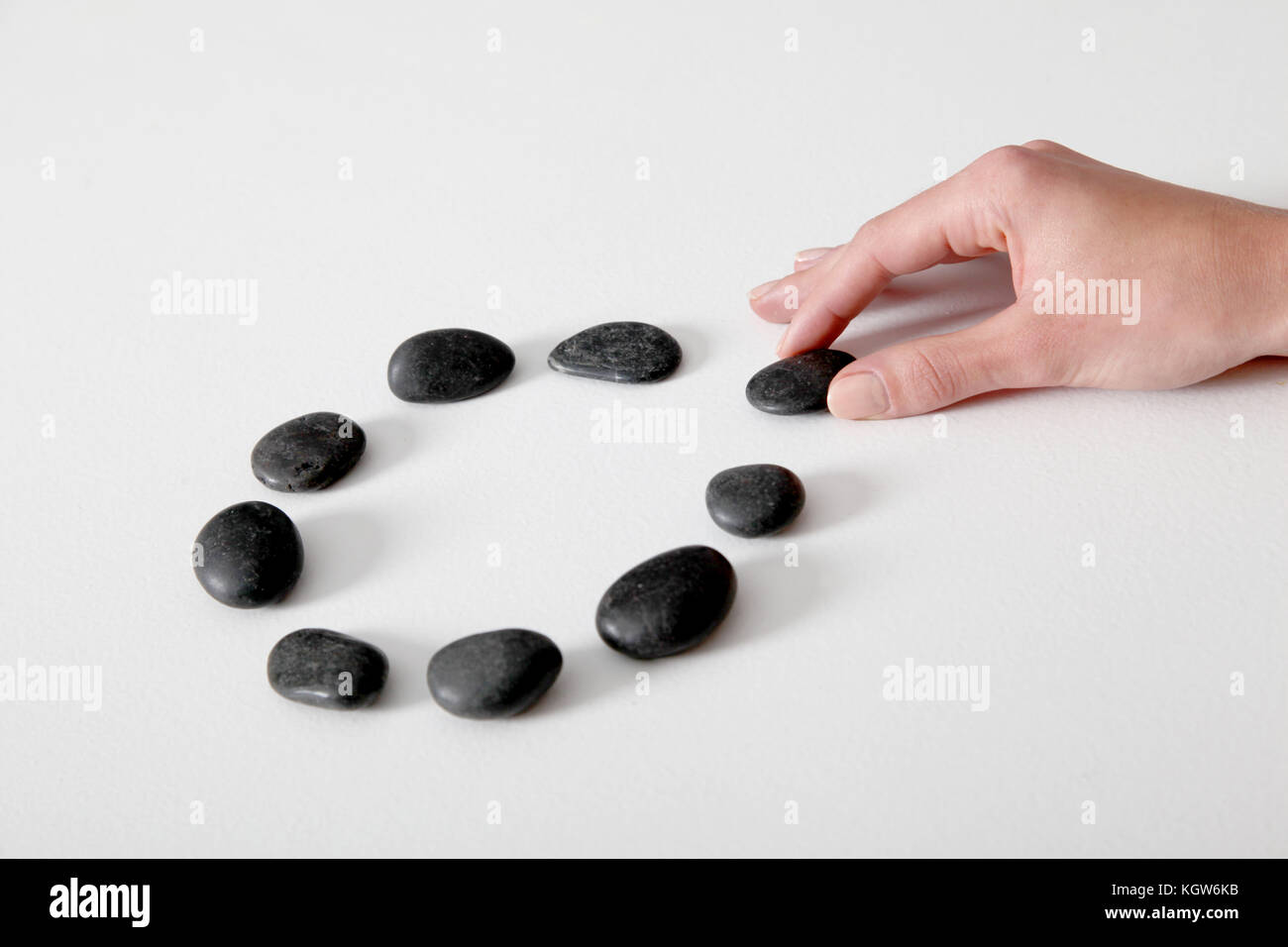 Human hand arranging line of pebbles in circle Stock Photo - Alamy