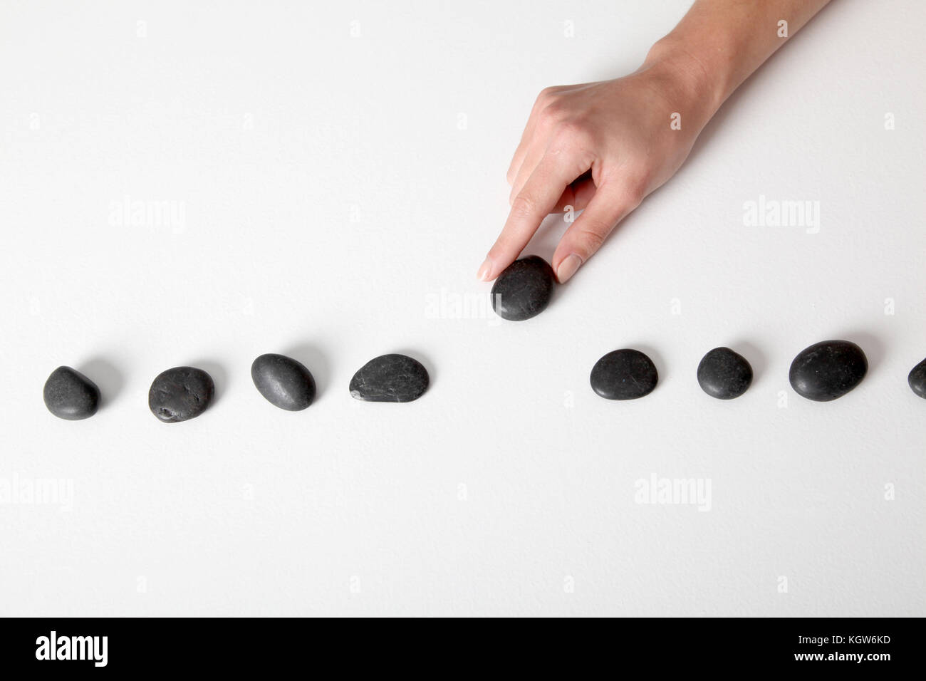Human hand arranging line of pebbles Stock Photo - Alamy