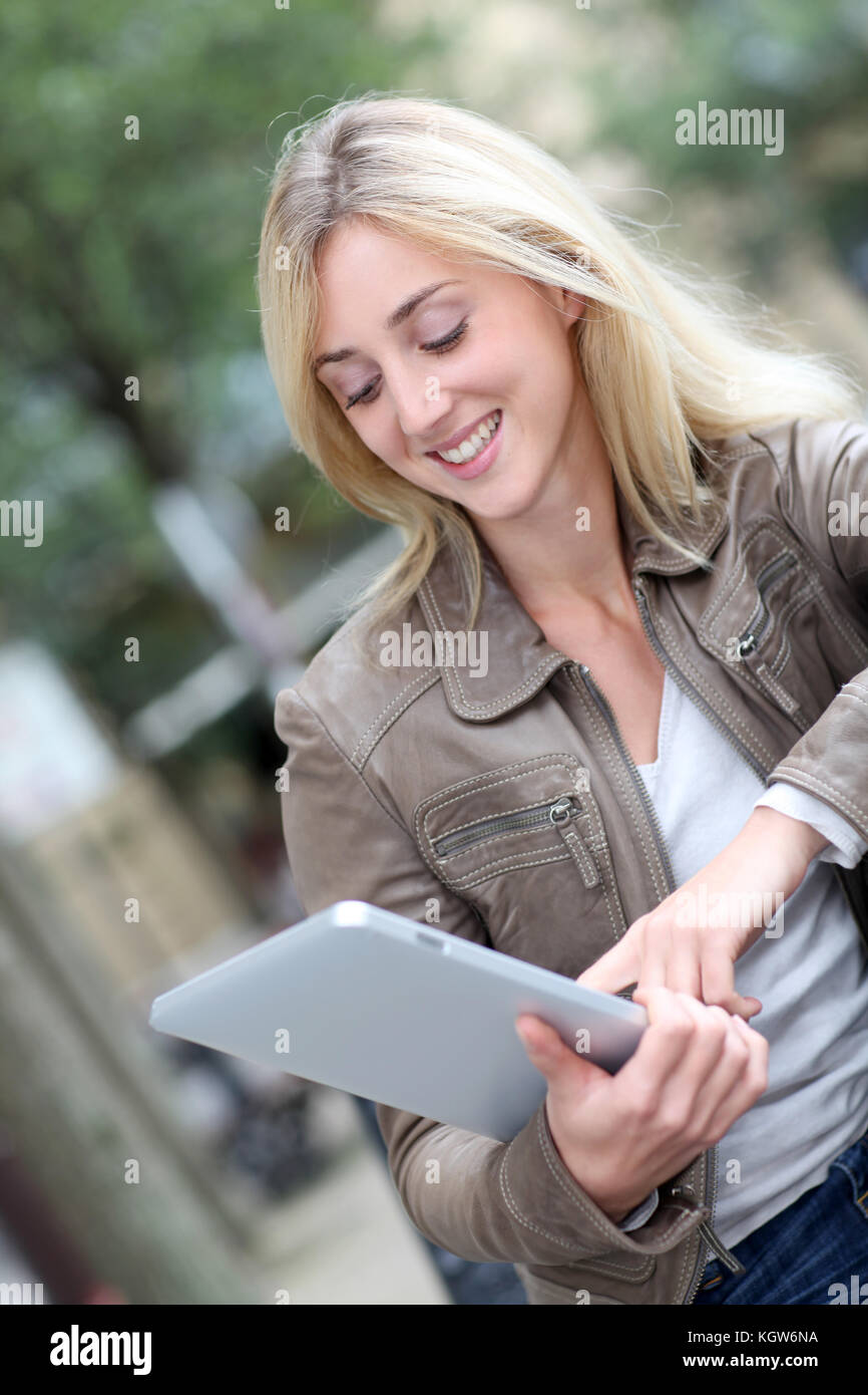 Beautiful woman using electronic tablet in public park Stock Photo - Alamy