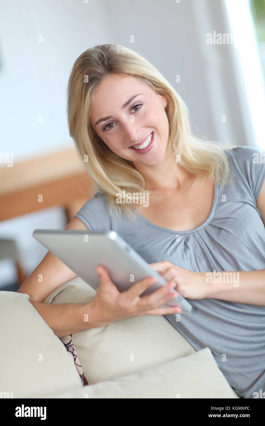 Young woman using electronic tablet in sofa Stock Photo - Alamy