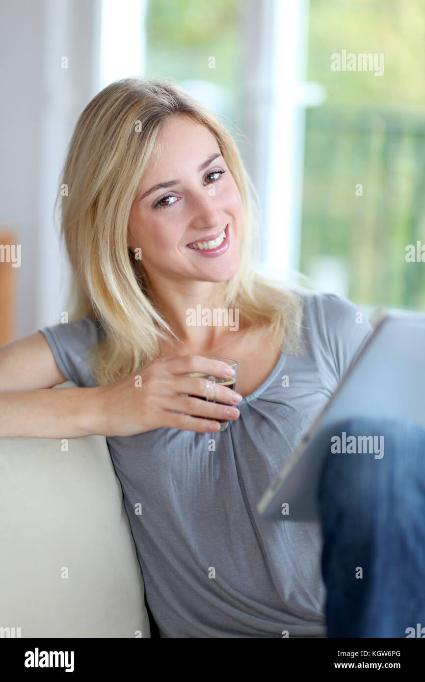 Young woman using electronic tablet in sofa Stock Photo - Alamy