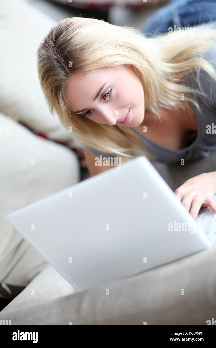 Girl laying in sofa with laptop computer Stock Photo - Alamy